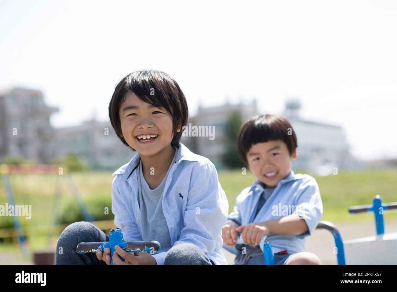 Brothers playing on the playground equipment at the park Stock Photo ...