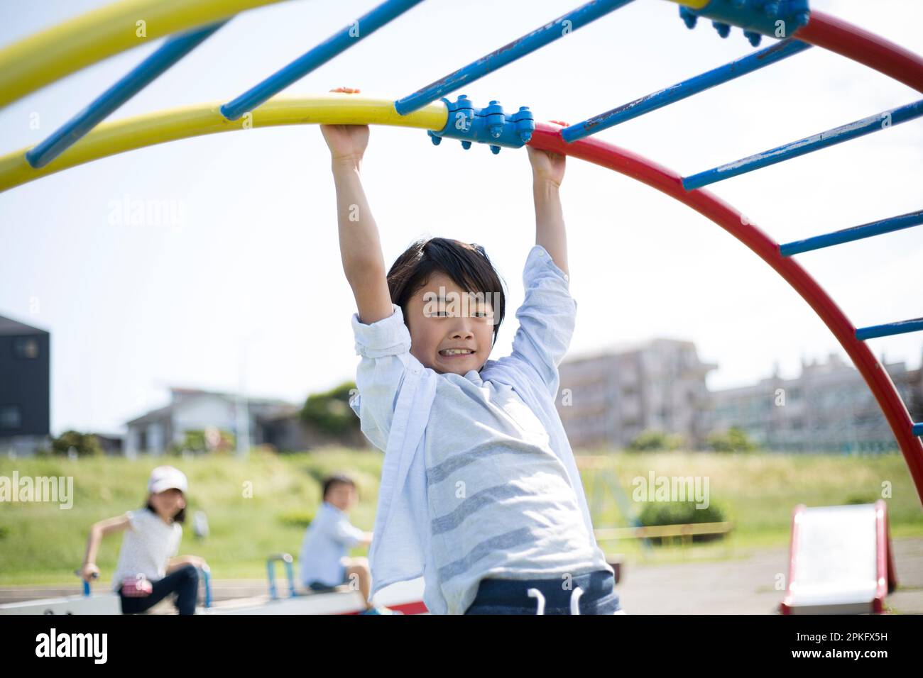 Elementary school boy playing on the playground equipment at the park ...