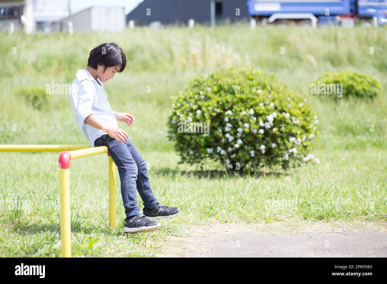 Boy sitting on fence Stock Photo - Alamy
