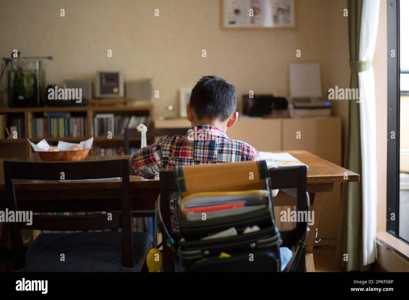 An elementary school boy doing his homework in the living room Stock ...