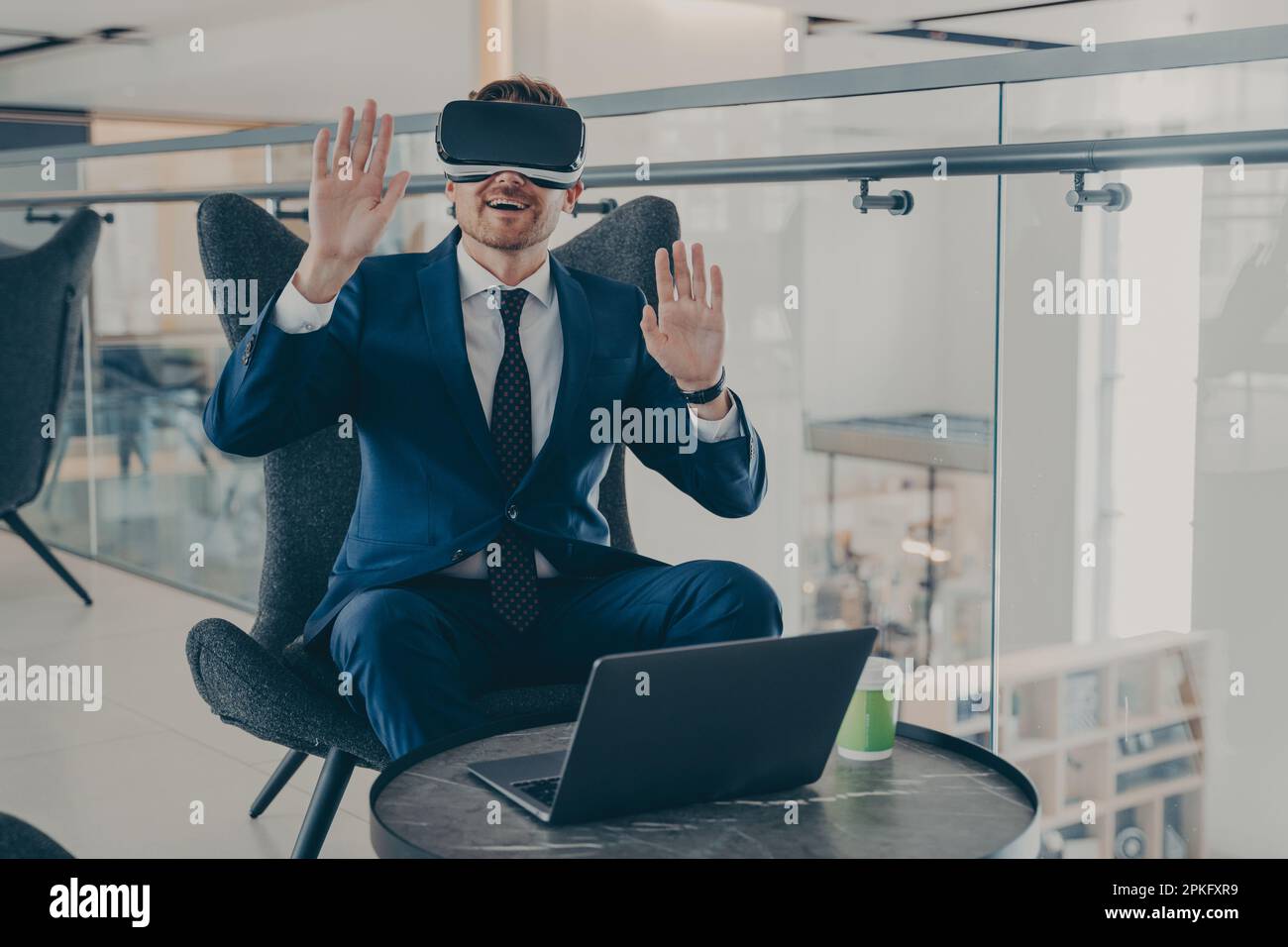 Businessman in formal suit and in VR headset glasses pointing with open ...