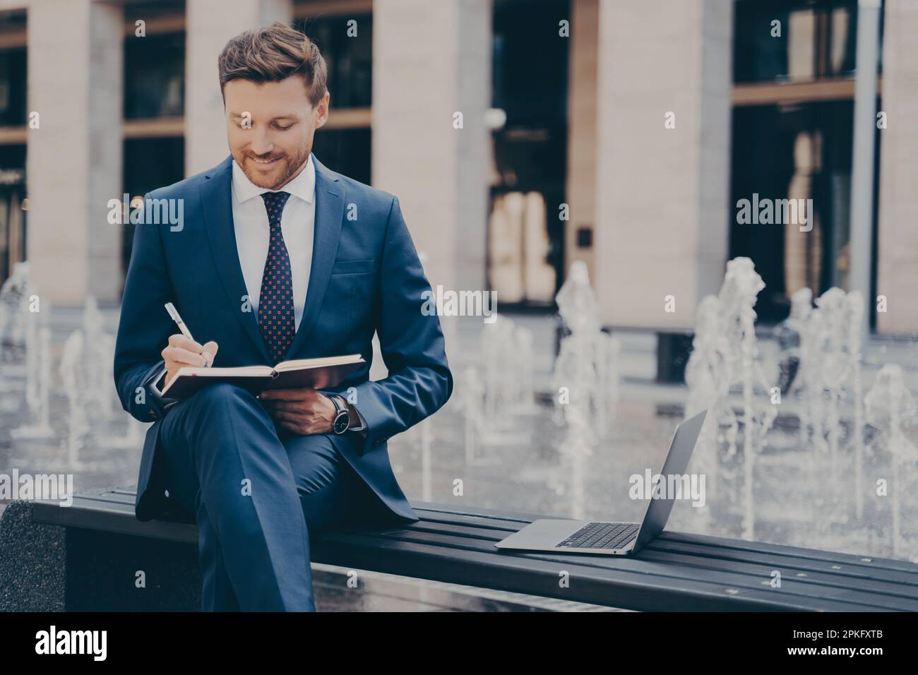 Thoughtful smiling young handsome professional entrepreneur in blue ...