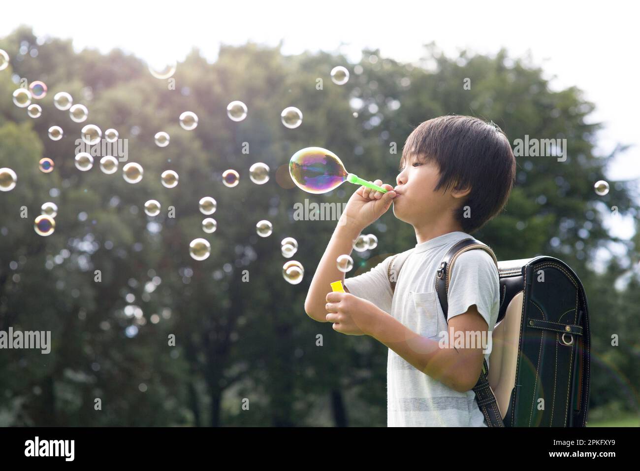 Elementary school boy playing with soap bubbles Stock Photo - Alamy