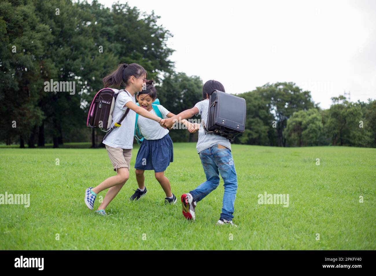 Elementary school children with school backpacks holding hands and ...
