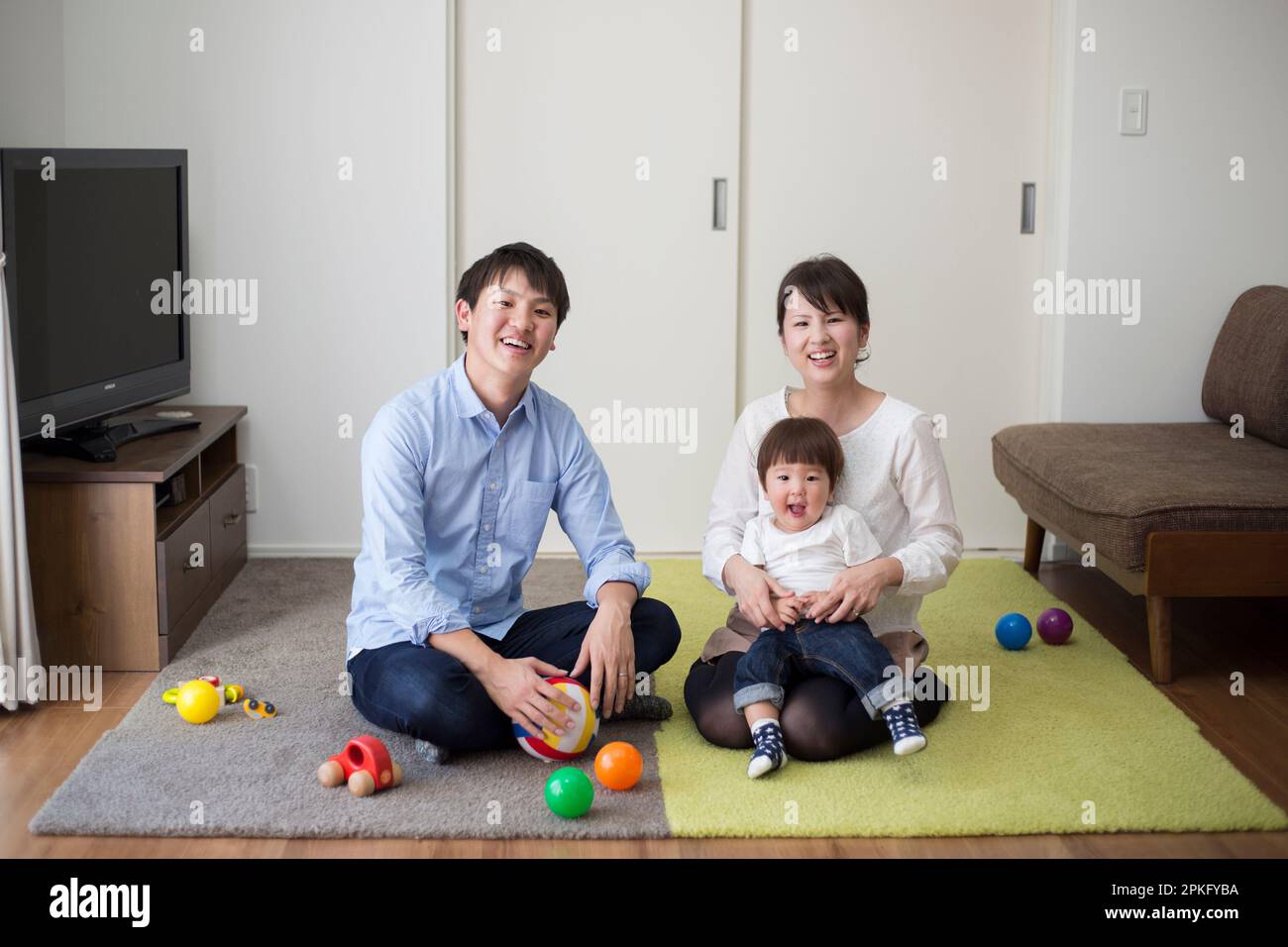 Family of three relaxing in the living room Stock Photo - Alamy