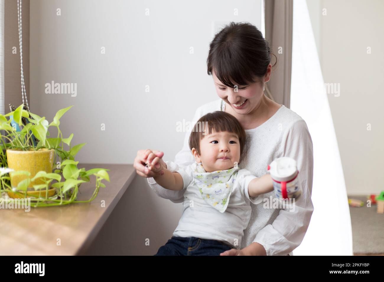 Infant sitting on mother's lap Stock Photo - Alamy