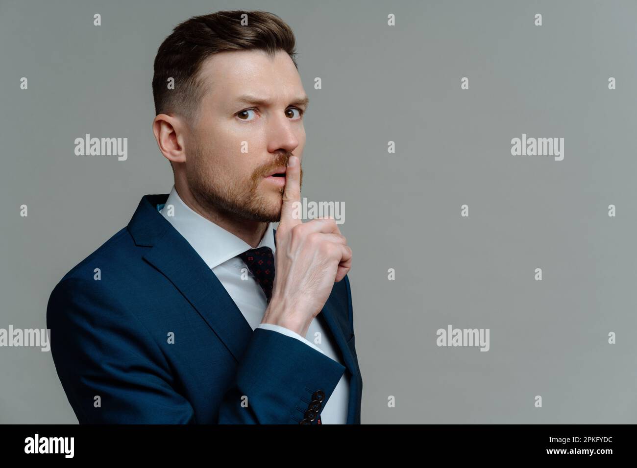 Serious bearded adult man makes shush gesture asks to be quiet tells ...