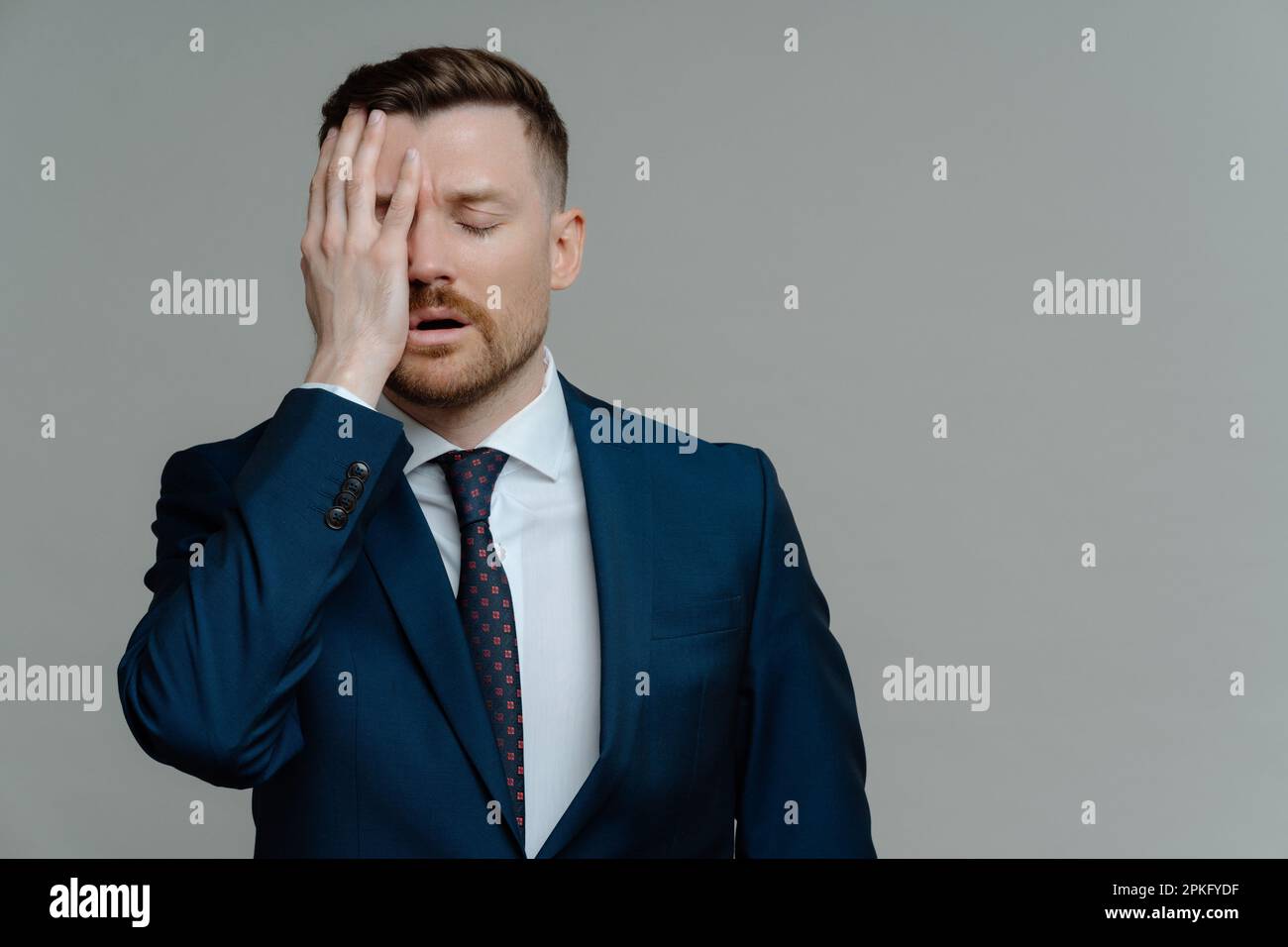 Horizontal shot of displeased bearded man manager makes face palm feels ...