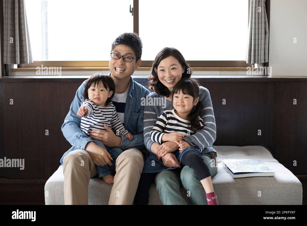 Family sitting on the sofa Stock Photo - Alamy