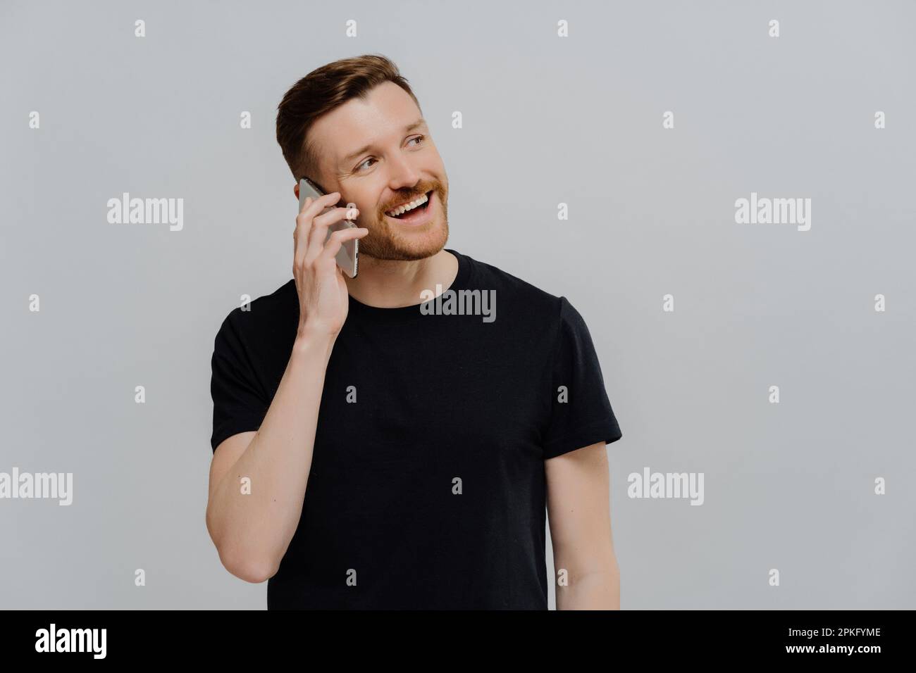 Happy young ginger man with stubble having pleasant conversation with ...