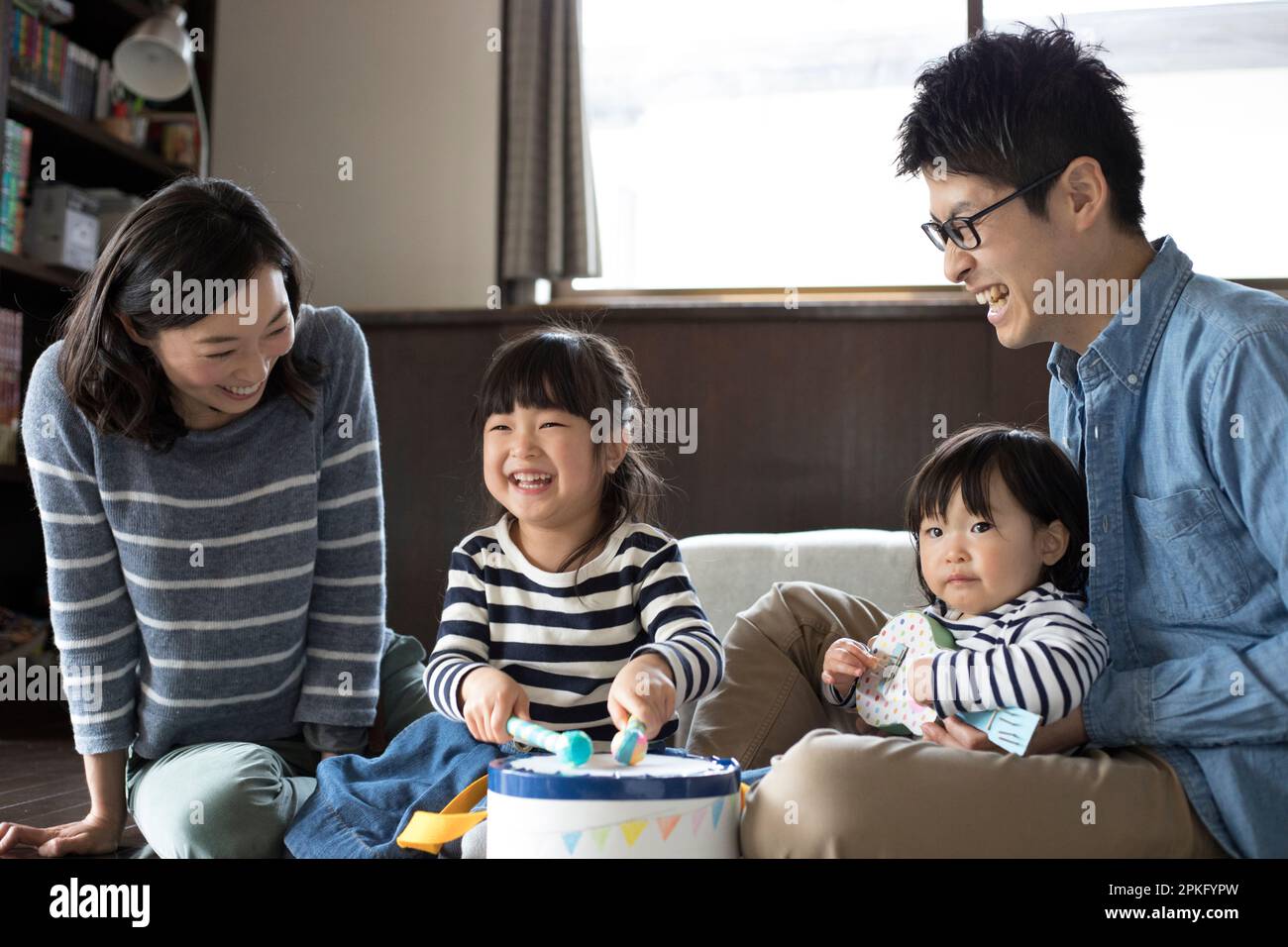 Sisters playing with a handmade musical instrument toy and their ...