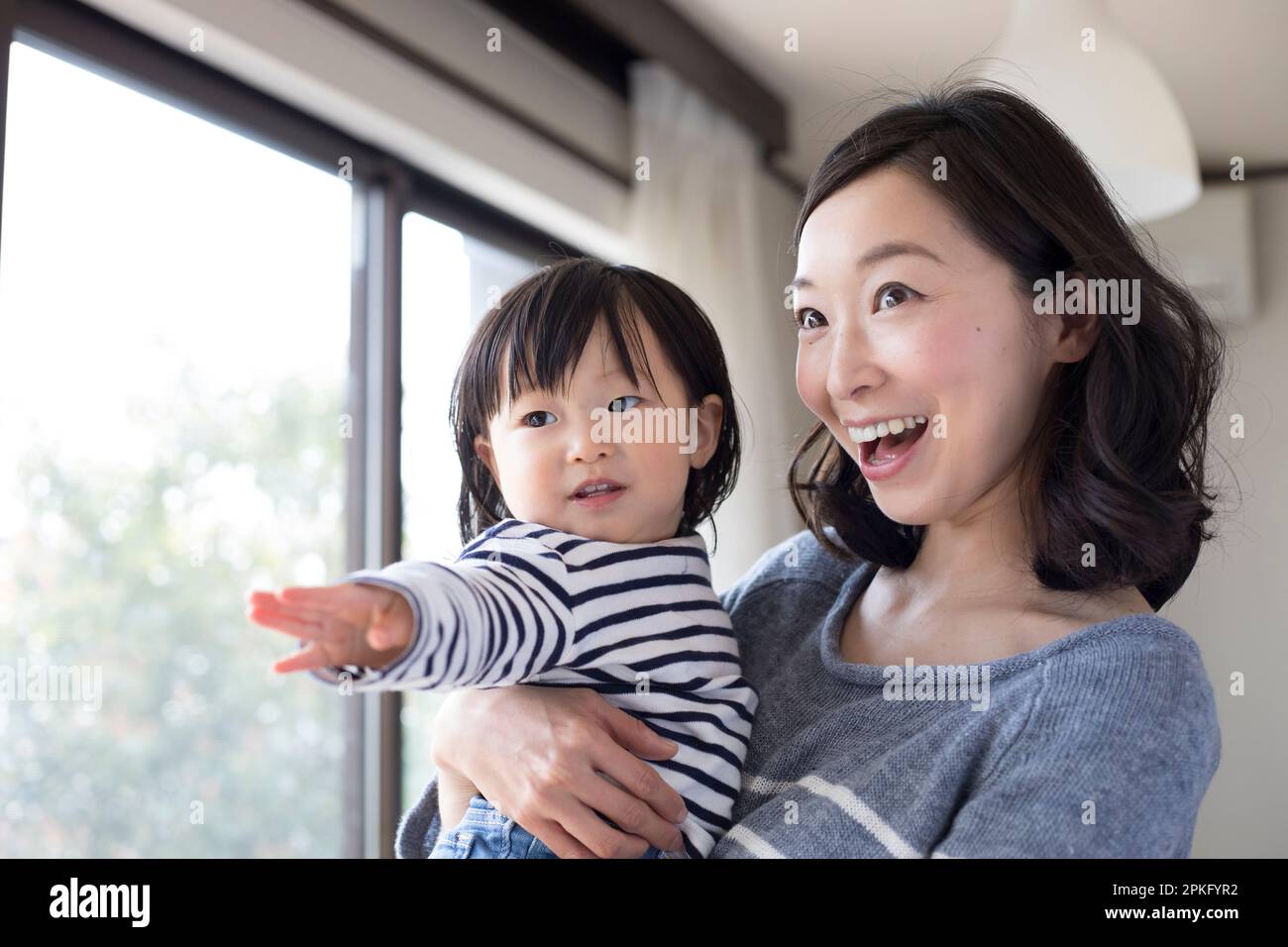 A child being carried by her mother Stock Photo - Alamy