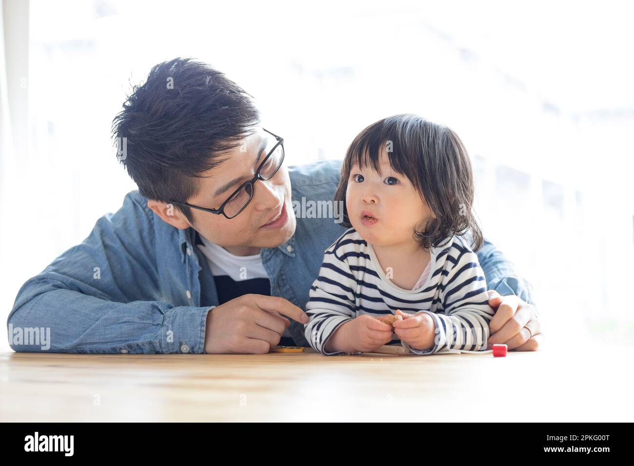 A baby sitting on her father's lap Stock Photo - Alamy