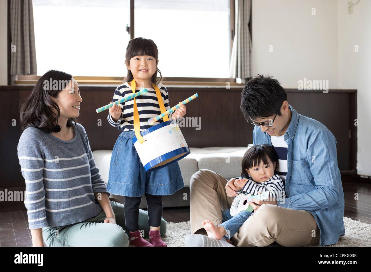 Family playing handmade musical instruments in living room Stock Photo ...