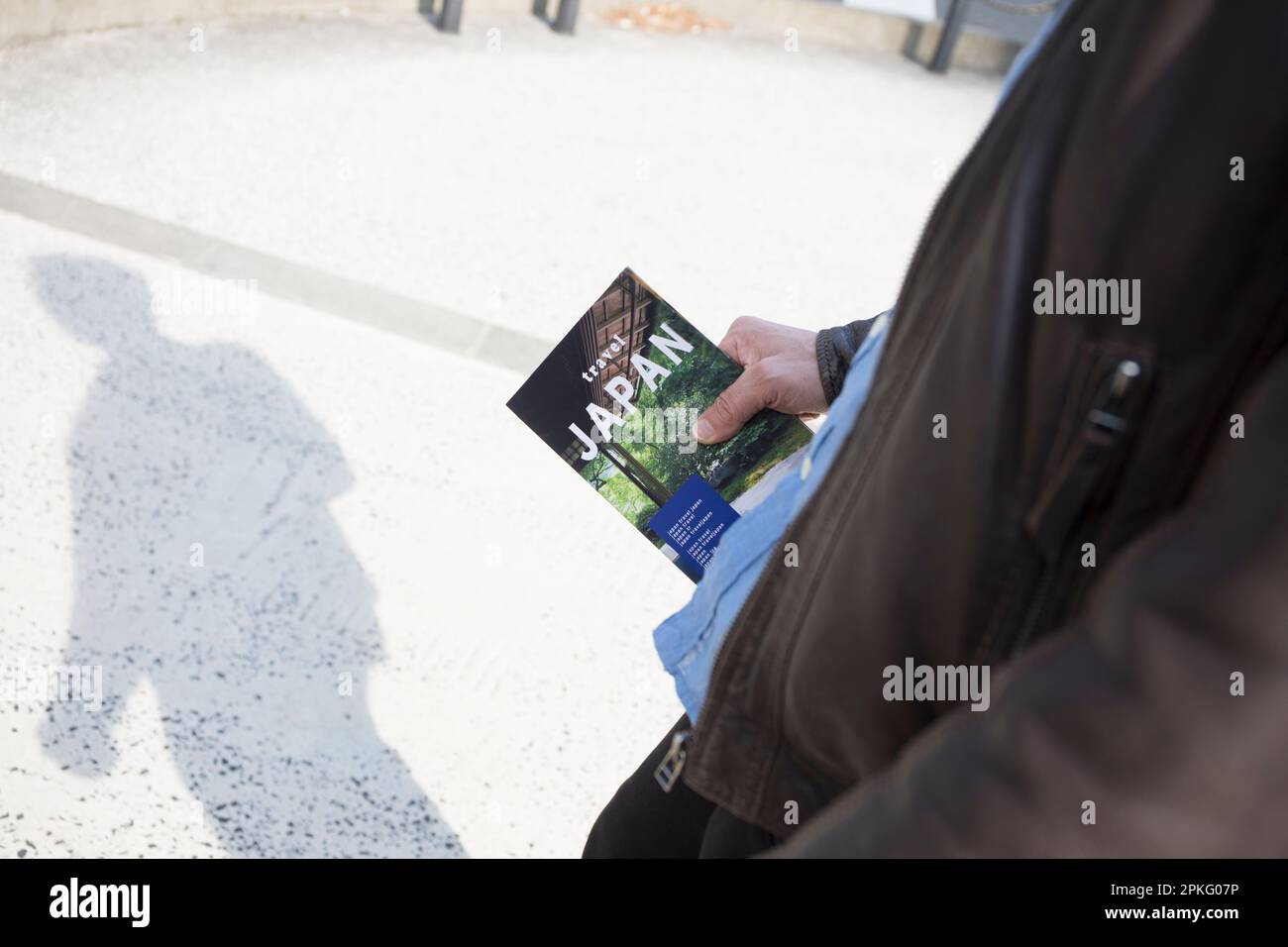 A foreign tourist walking with a guidebook in his hand Stock Photo - Alamy