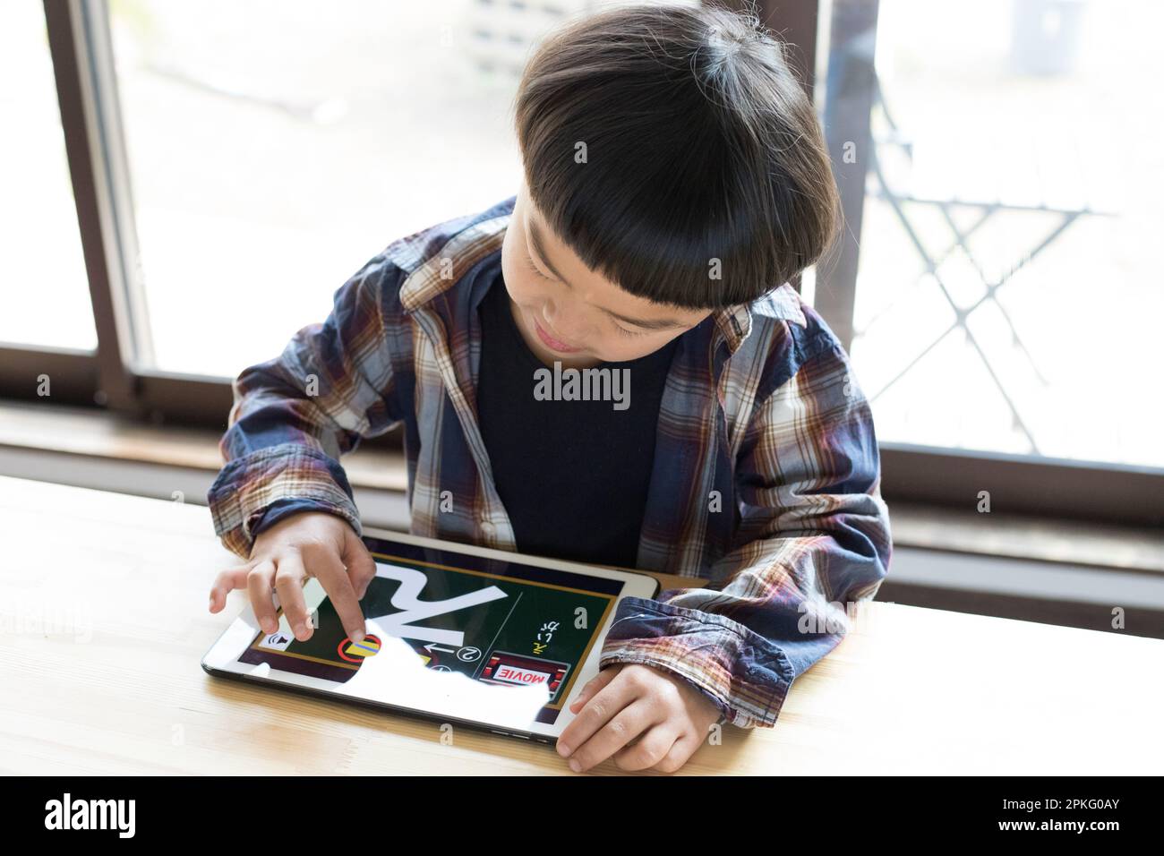 A boy practicing hiragana on a tablet Stock Photo - Alamy