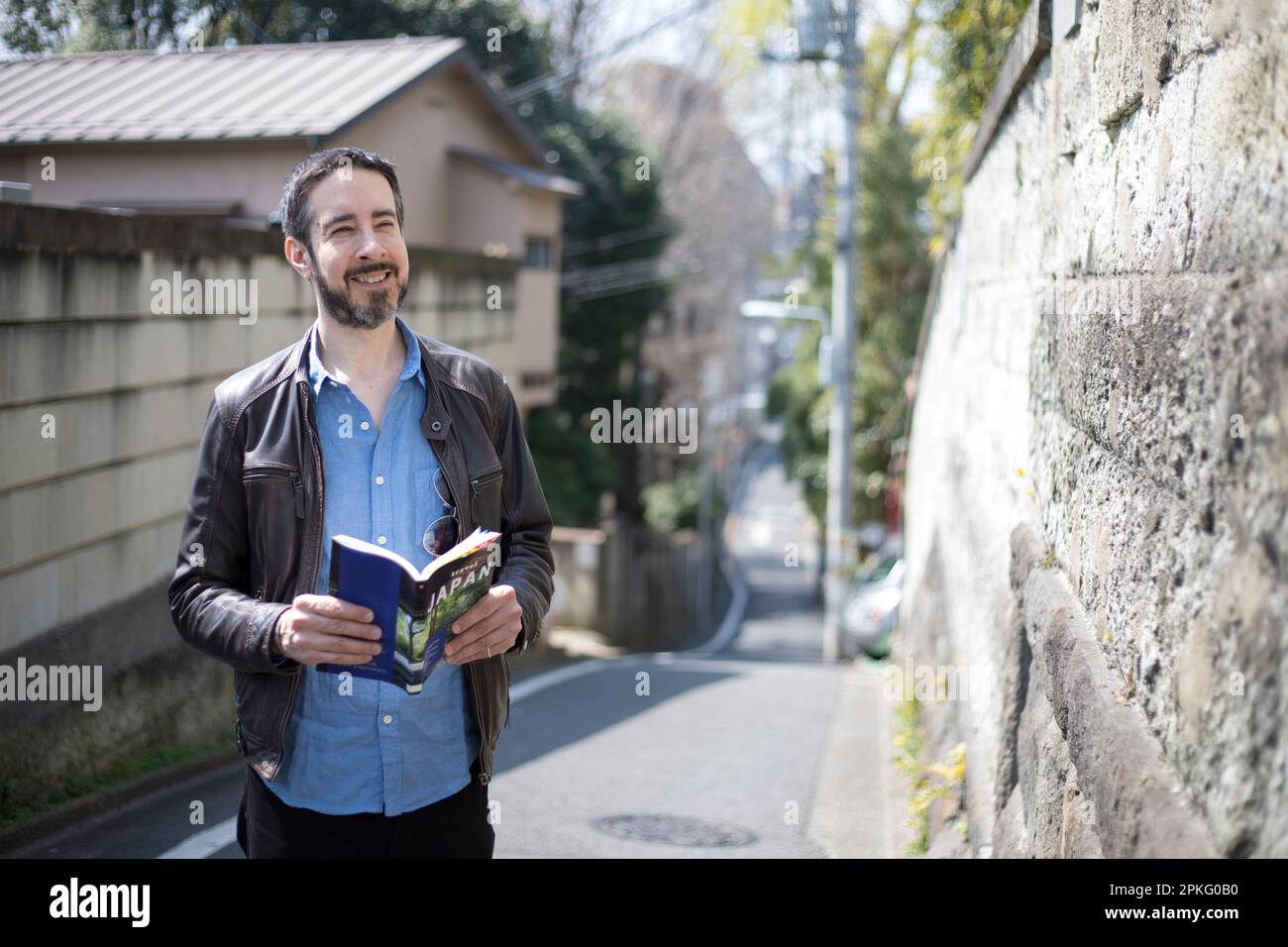 Foreign tourists walking through town with a guidebook Stock Photo - Alamy