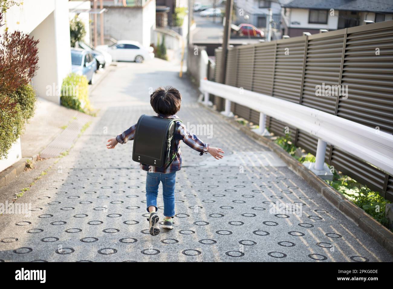 A boy walking with his school bag on his back Stock Photo - Alamy