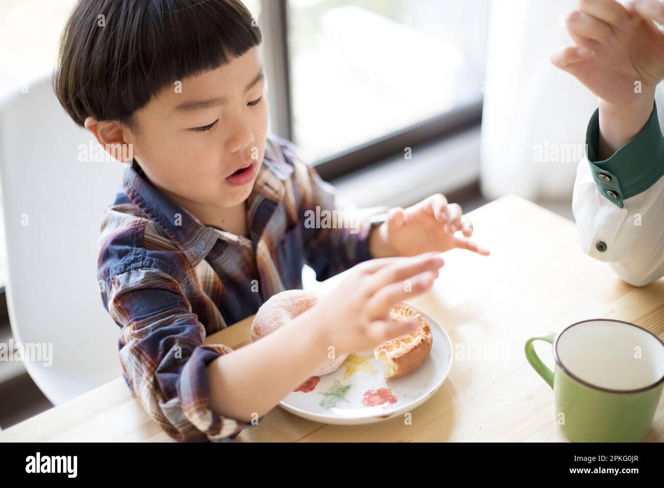 Boy eating a doughnut as a snack Stock Photo - Alamy