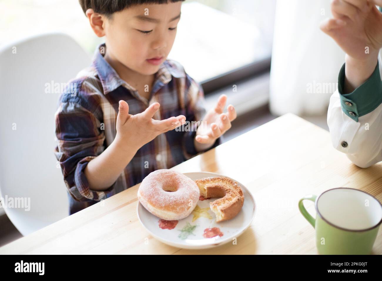 Boy eating a doughnut as a snack Stock Photo - Alamy