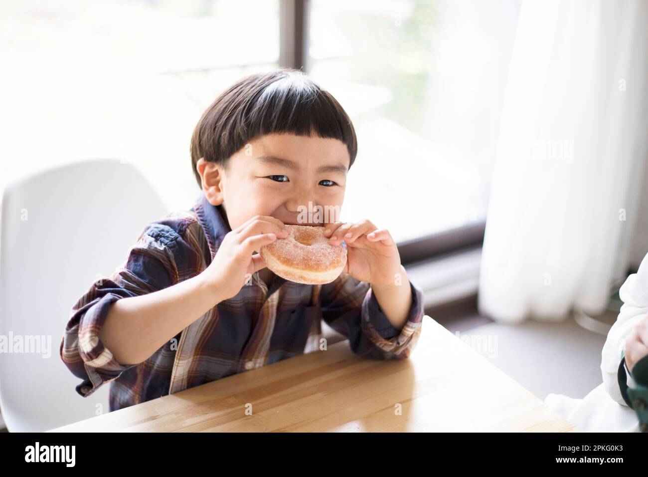 Boy eating a doughnut as a snack Stock Photo - Alamy