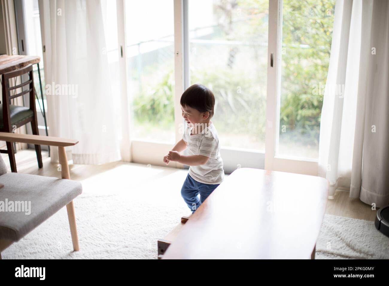 Toddler playing alone in the living room Stock Photo - Alamy