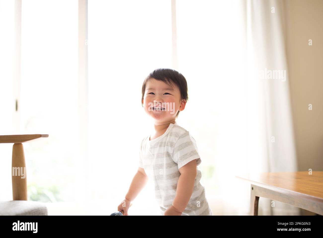 Toddler playing alone in the living room Stock Photo - Alamy