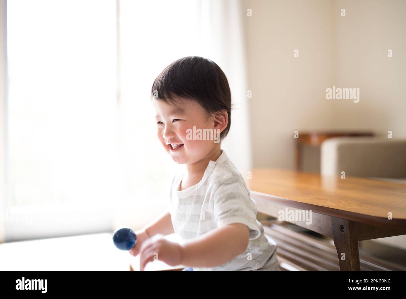 Toddler playing alone in the living room Stock Photo - Alamy