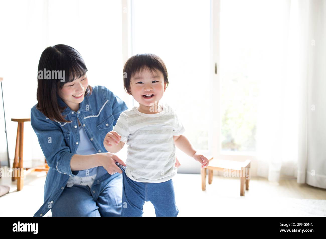 Mother changing children's clothes Stock Photo - Alamy