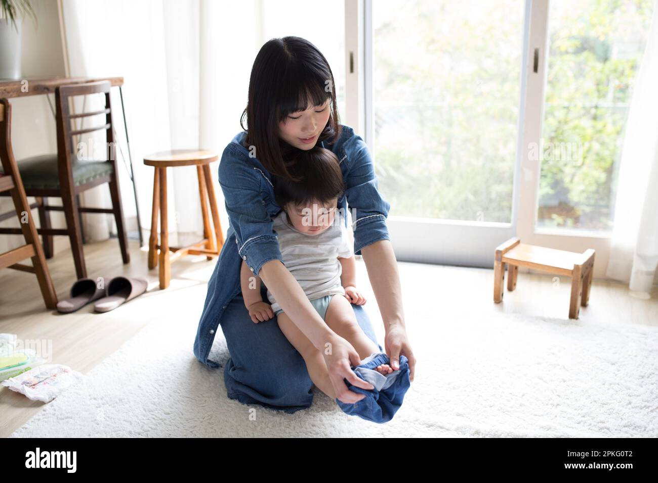 Mother changing her child Stock Photo - Alamy