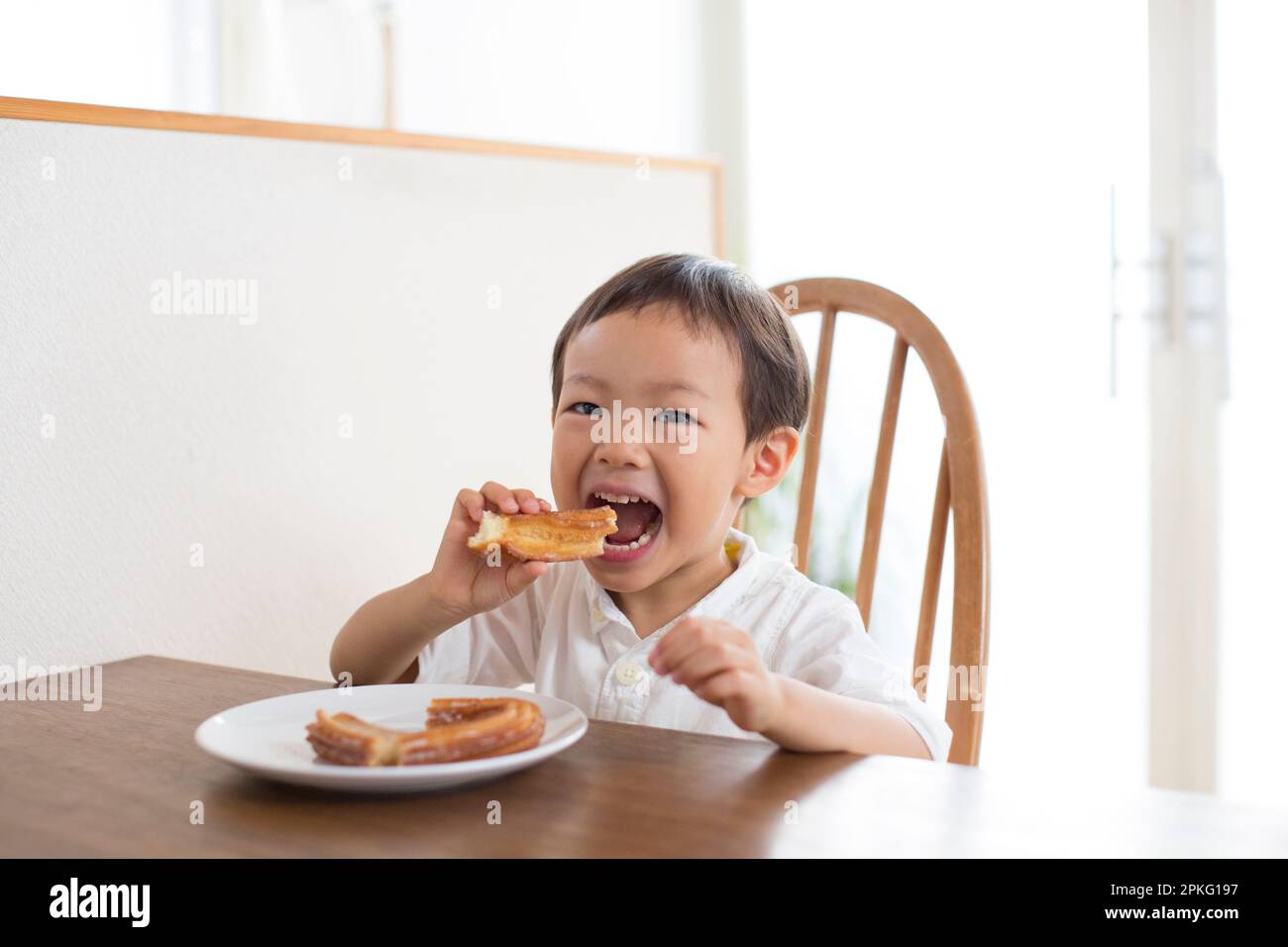 Boy eating snack at the table Stock Photo - Alamy