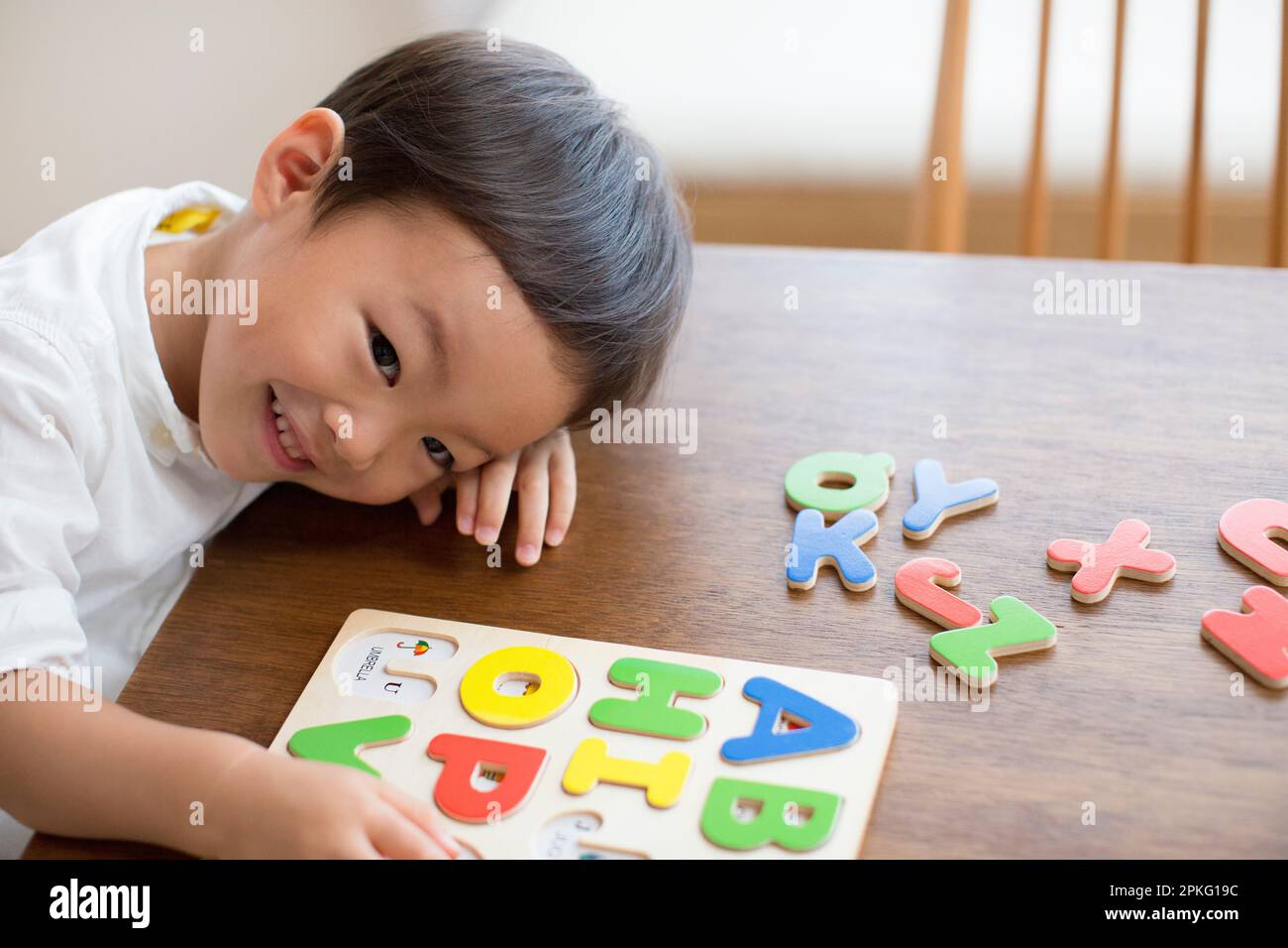 Boy playing with English puzzle Stock Photo - Alamy