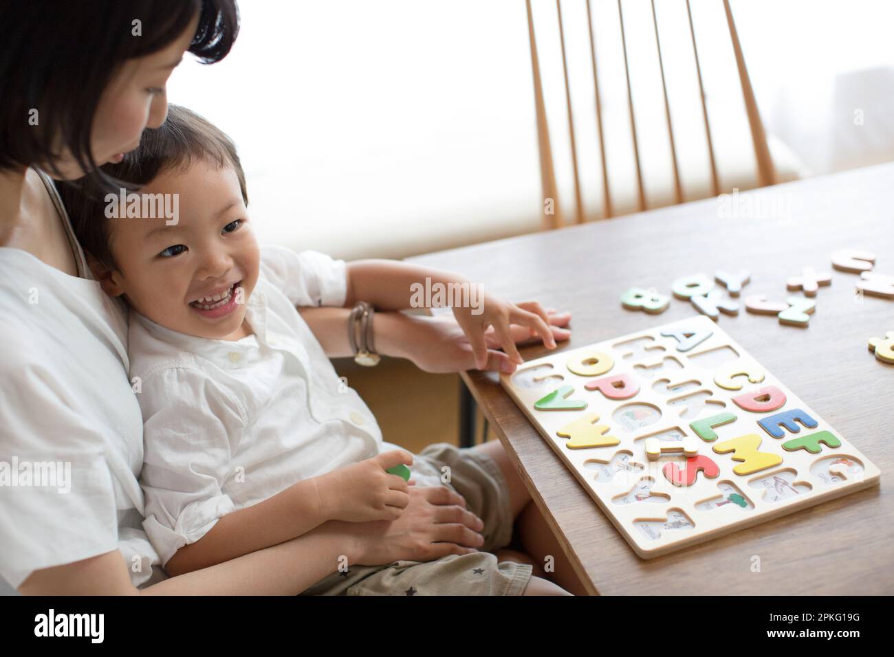 Boy learning English with English educational toys and mother helping ...