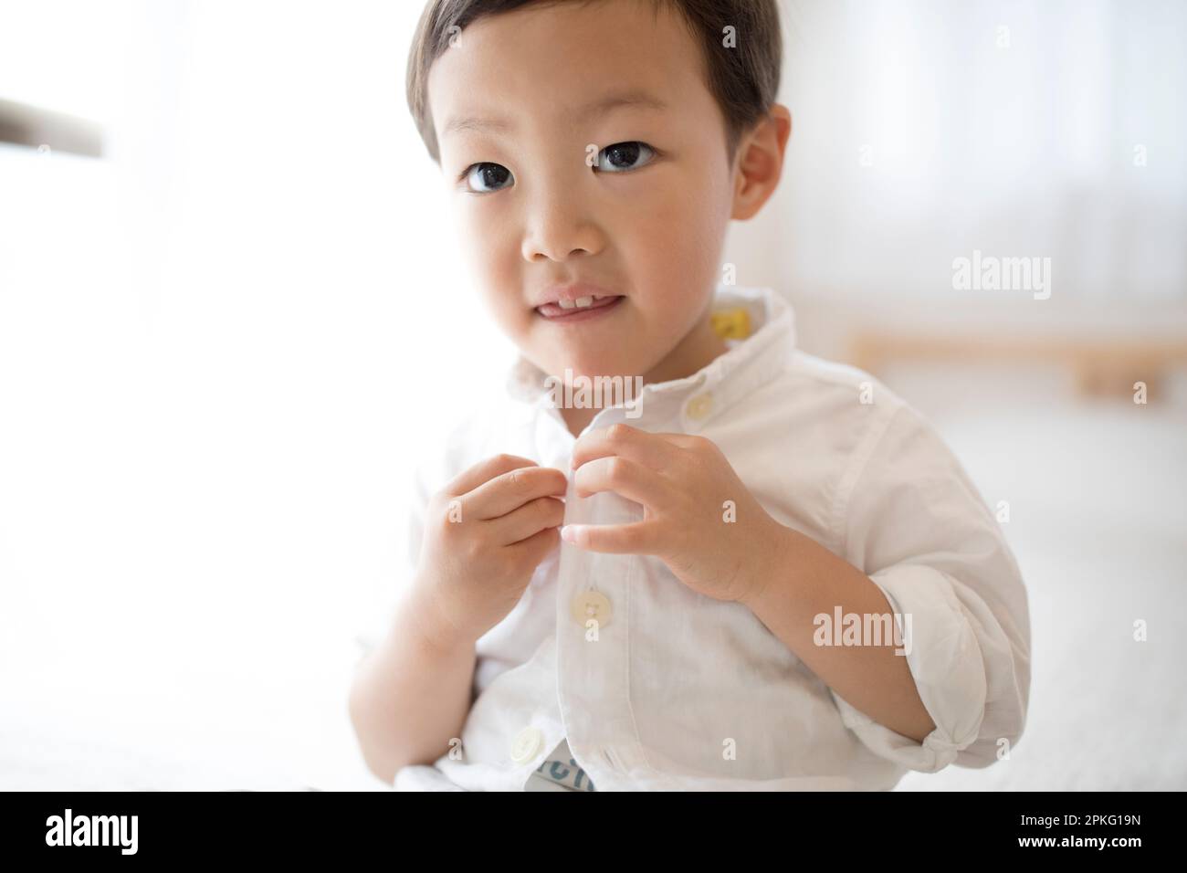 Boy buttoning up his clothes Stock Photo - Alamy