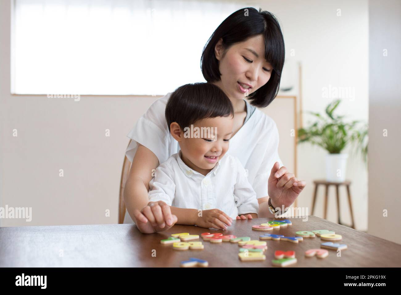 Boy learning English with English educational toys and his mother ...