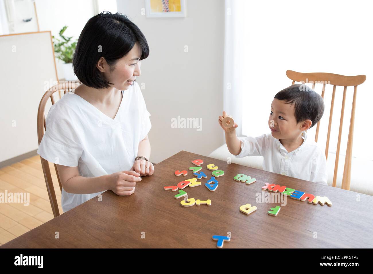 Boy learning English with English educational toy and mother helping ...