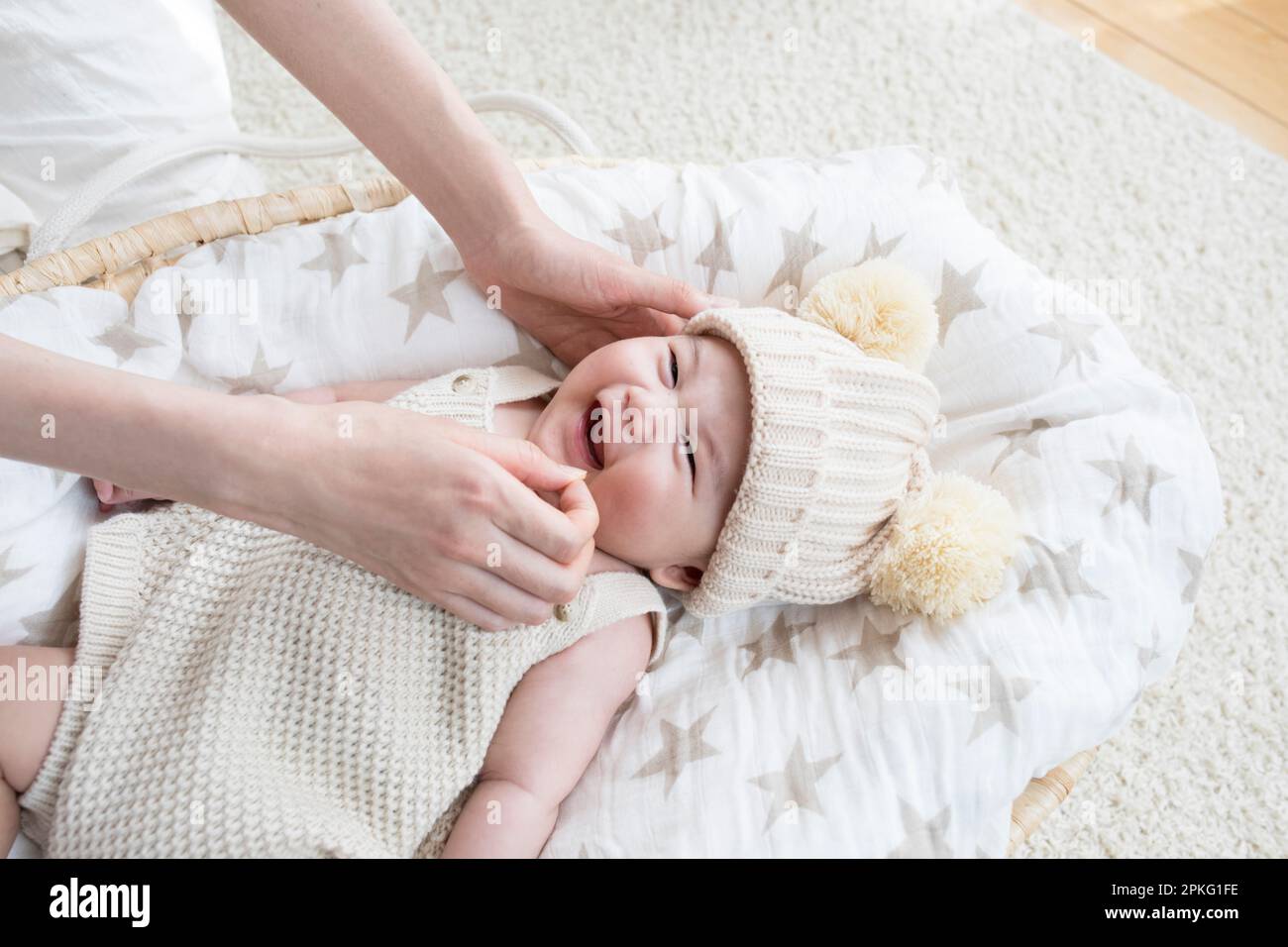 Smiling baby sleeping in the cooler and being soothed by its mother ...