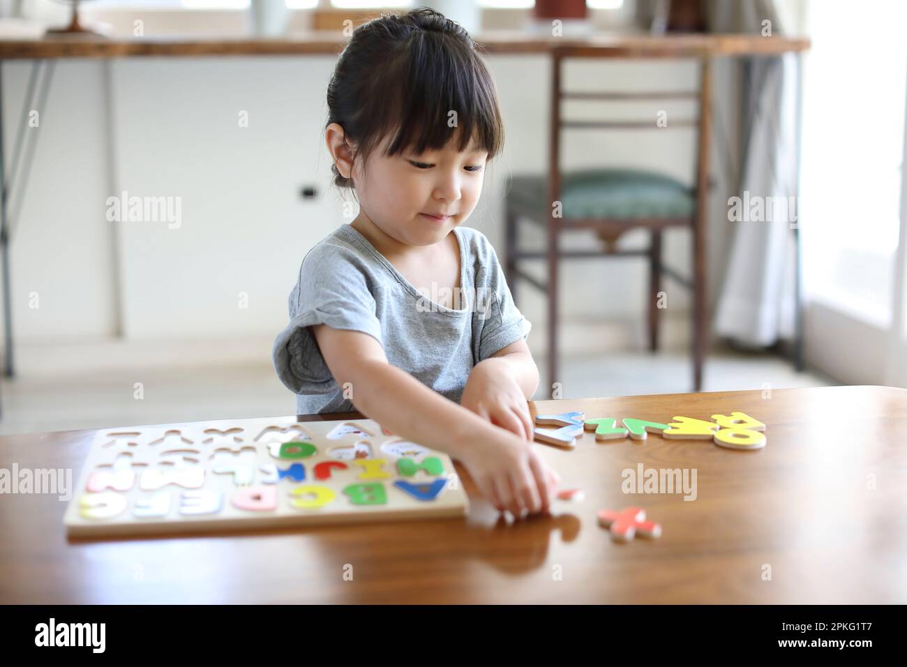 Girl doing alphabet puzzle Stock Photo - Alamy