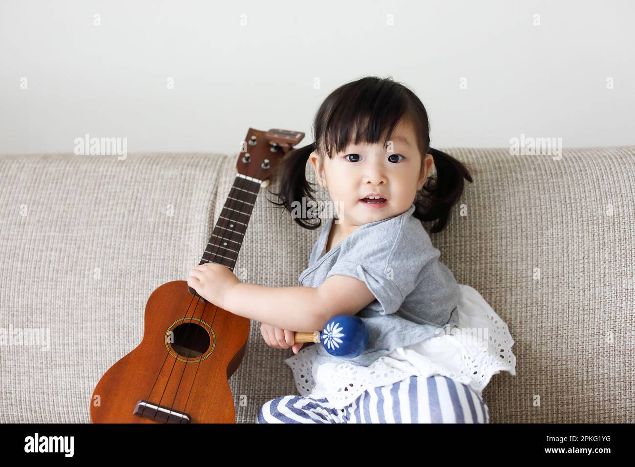 Little girl playing with musical instruments Stock Photo - Alamy