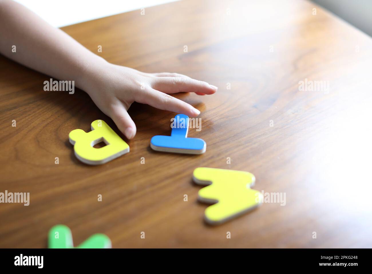 Child's hand with alphabet puzzle Stock Photo - Alamy
