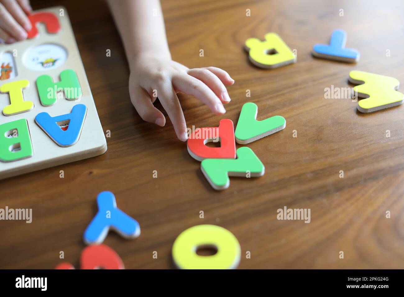 Child hands with alphabet puzzle Stock Photo - Alamy