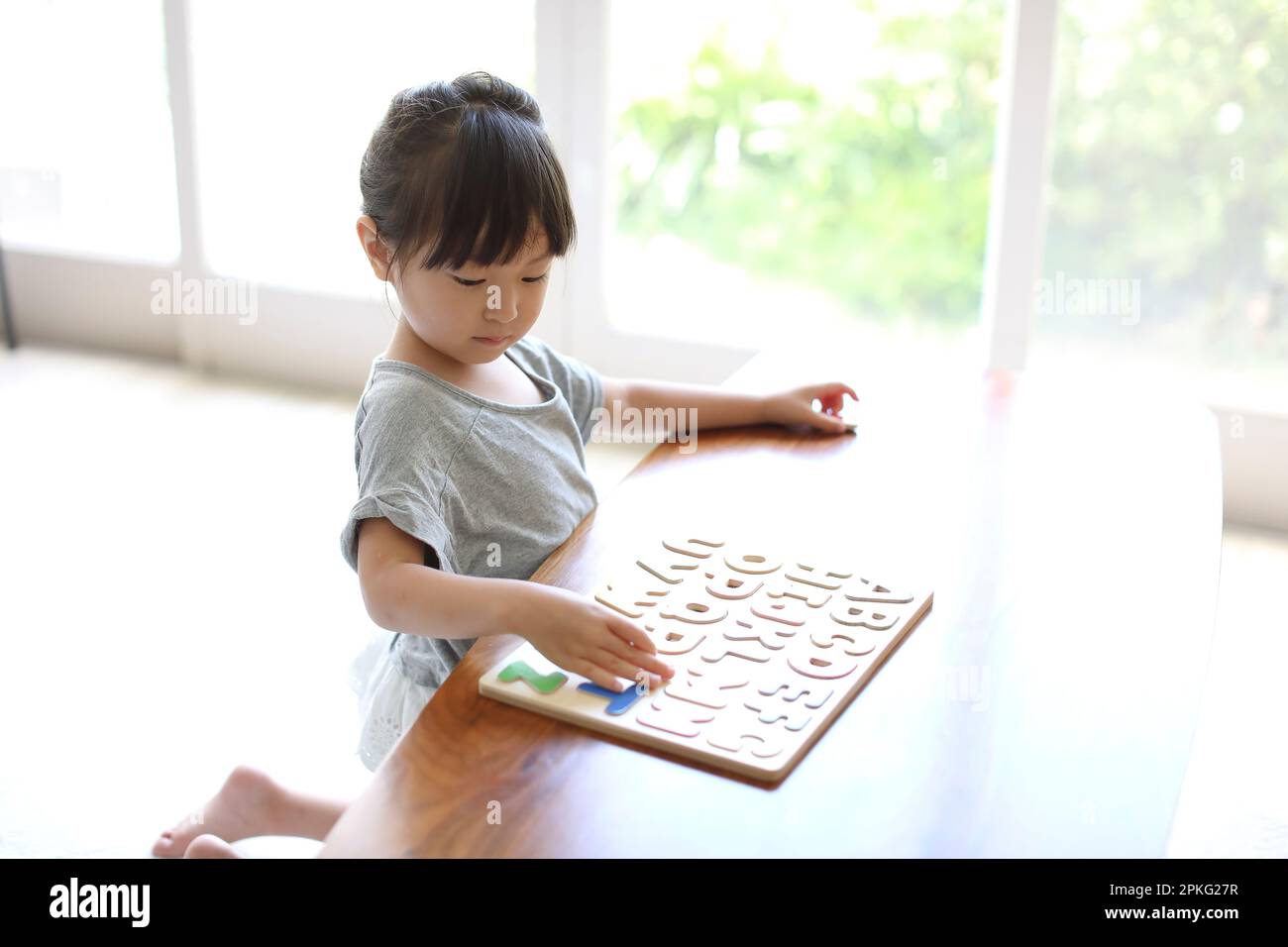 Girl doing alphabet puzzle Stock Photo - Alamy