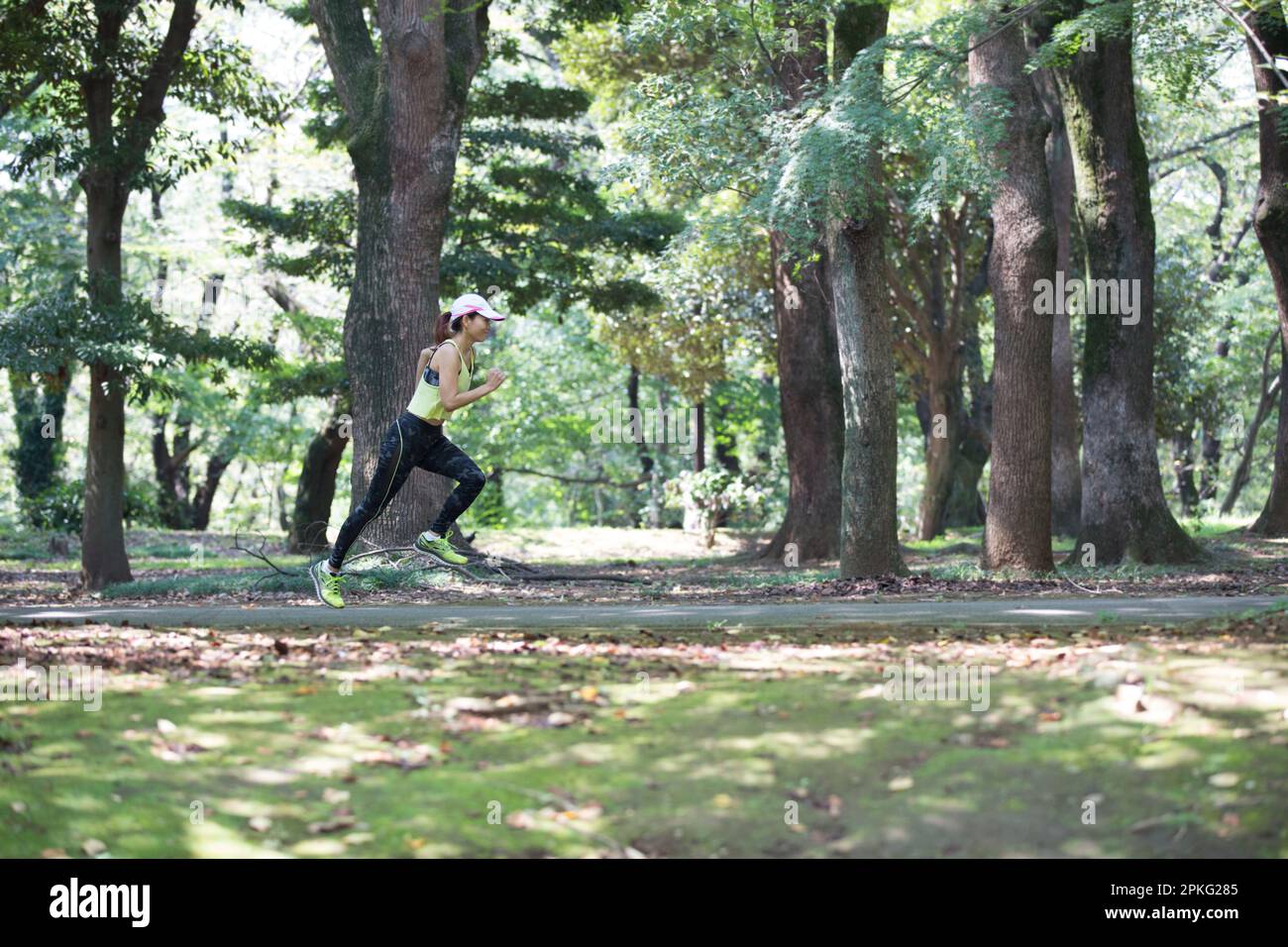 Woman running through the trees Stock Photo - Alamy