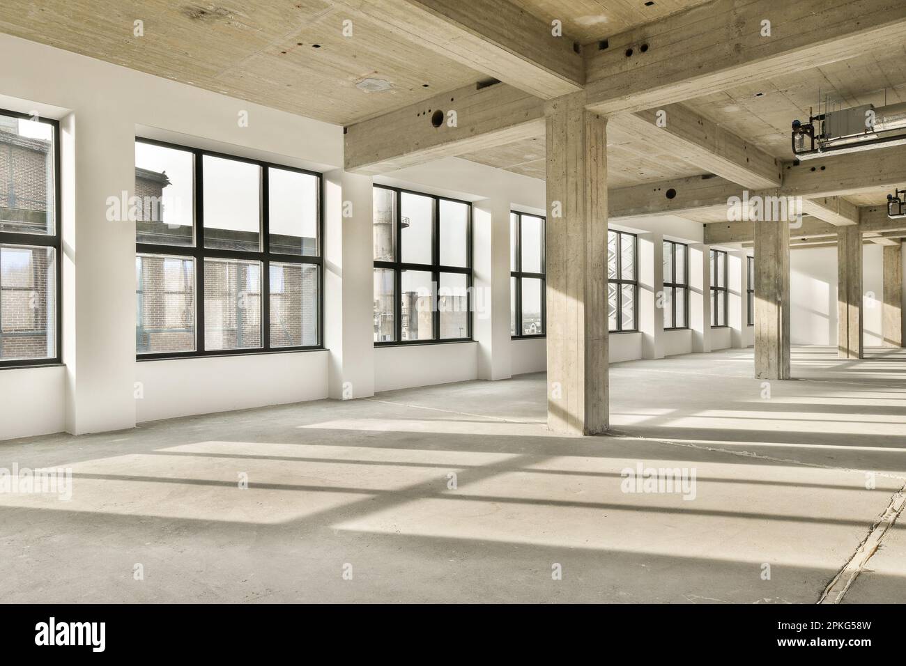 an empty building with windows and light coming in from the sun shining ...