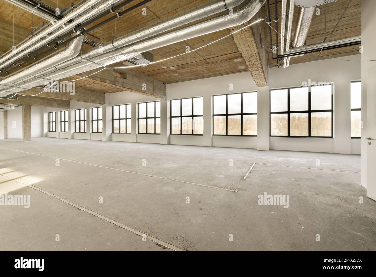 an empty office space with exposed ceiling and large windows in the ...