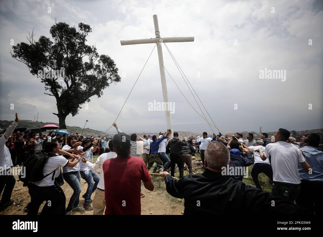 Faithful raise a giant wooden cross before the Árbol de la Vida or Tree ...