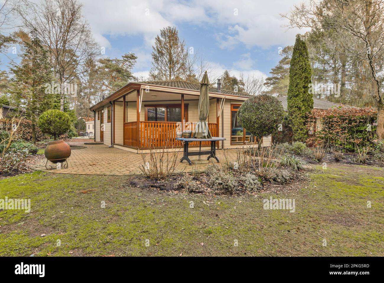a house in the middle of a garden with trees and shrubs around it there ...
