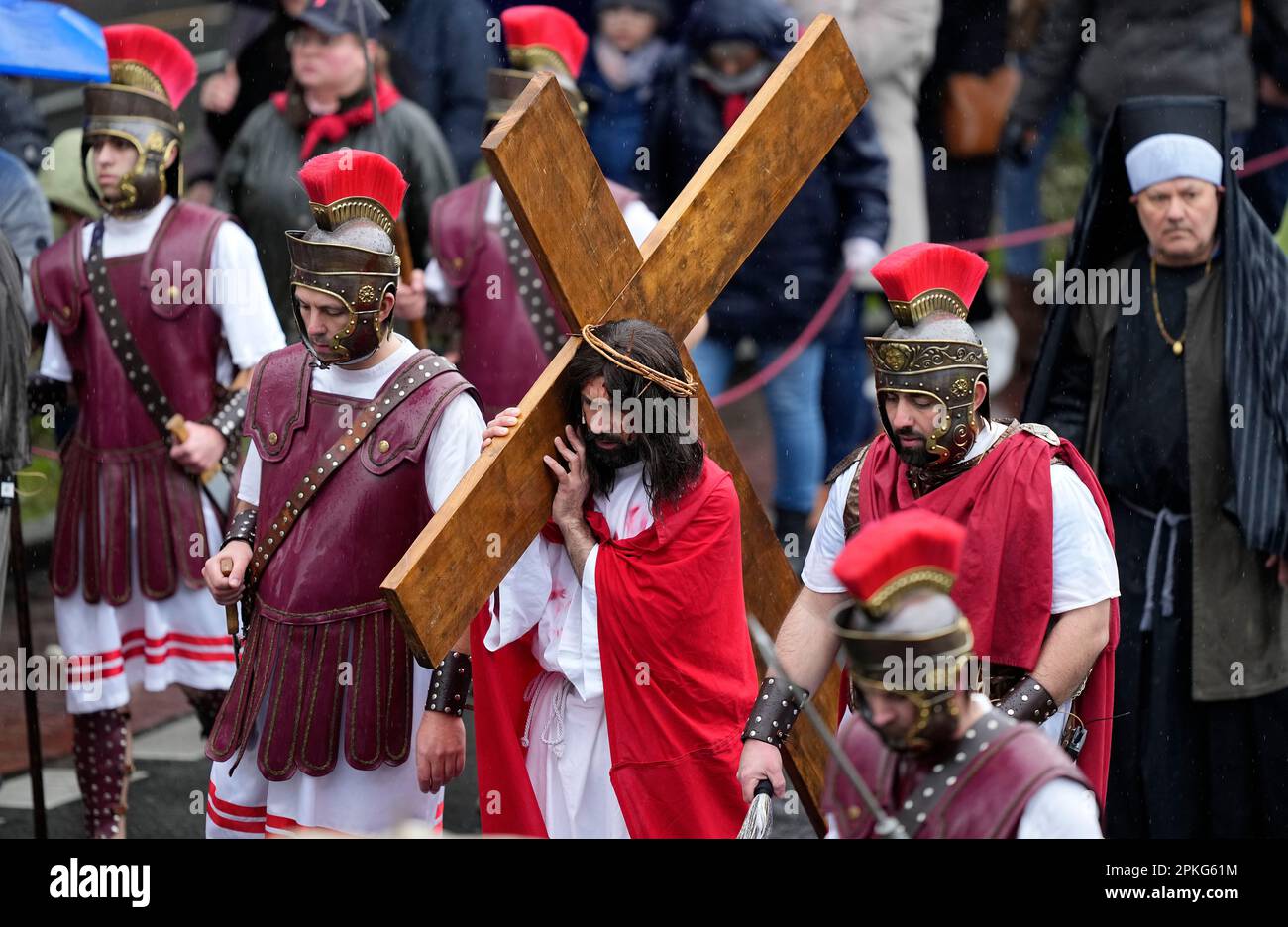 An actor portraying the part of Jesus Christ, carries the cross during ...