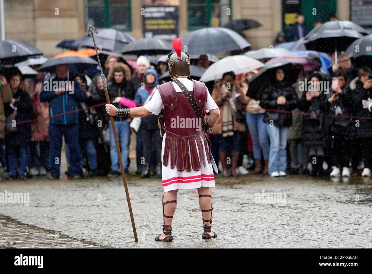An actor in a Roman costume stands in front of spectators under ...