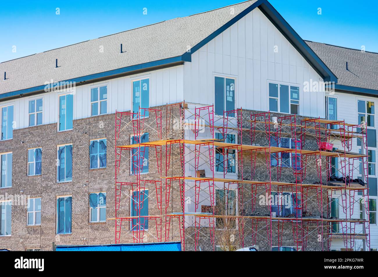 Horizontal shot of brick-layers scaffolding around a new multi-story ...
